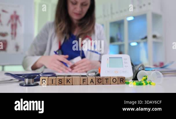 Wooden blocks spell words Risk Factor on medical desk near monitor and ...