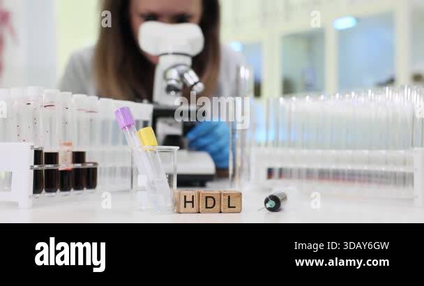 Abbreviation HDL appears on wooden blocks near microscope and test ...