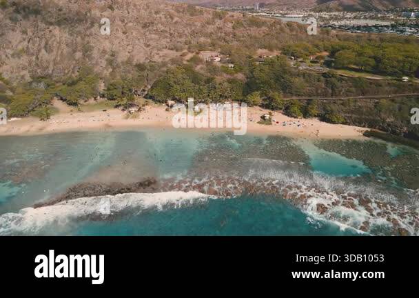 Beachgoers enjoy a sunny day at a beach in Hawaii. Families and groups ...