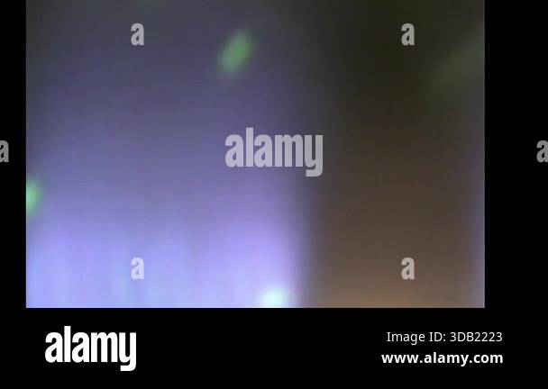 Defocused VHS frame with soft purple glow and faint green light spots ...