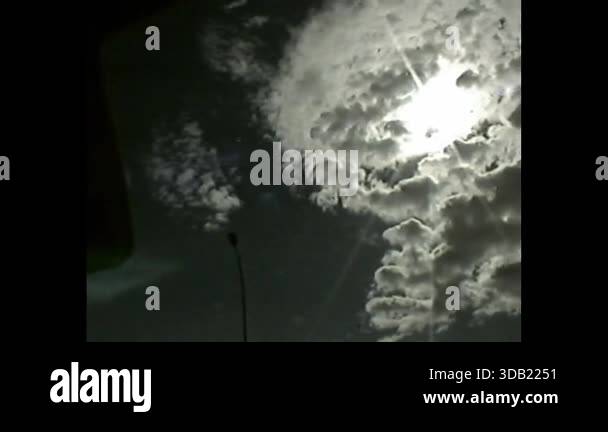 Man in drivers seat captured in dim light with grainy VHS-style visual ...