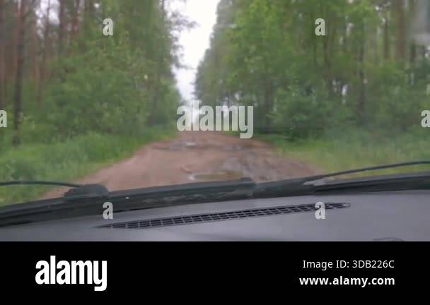Point of view shot from inside a car driving on a bumpy dirt road ...