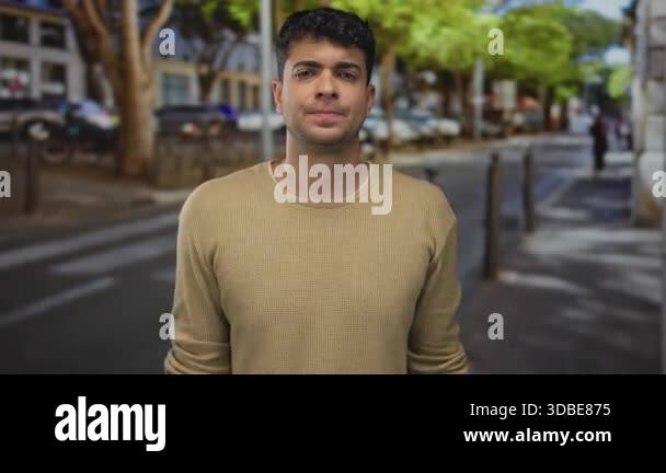 Man shields ears covering street commotion, guy young hispanic urban ...