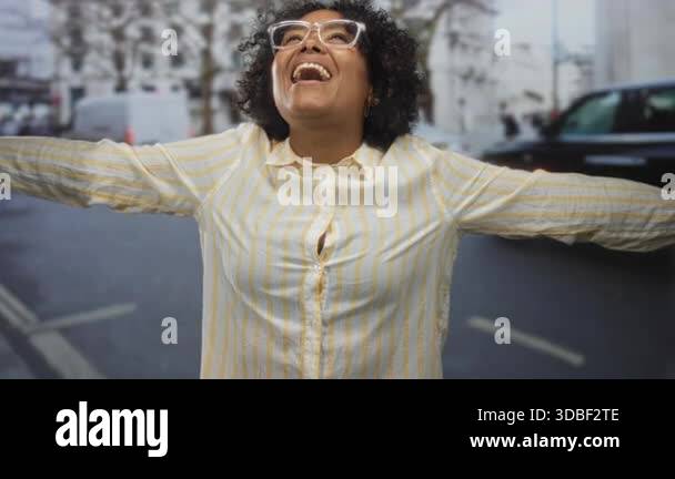 Woman spreads arms on busy city street amid moving cars with broad ...