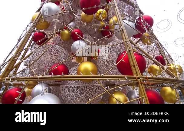 A creative urban Christmas tree made of red, silver and gold balls with ...