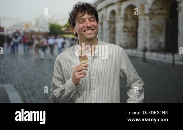 Hispanic man enjoying ice cream in front of the iconic colosseum in ...