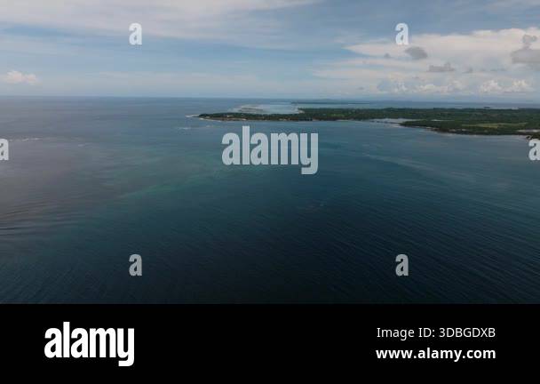 A wide view of the sea with an island visible in the distance. Siargao ...