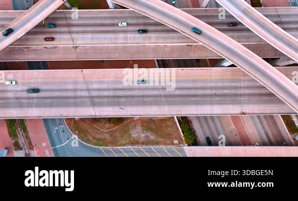 Descend over the multi-lane road on the trestle. Numerous cars rode by ...