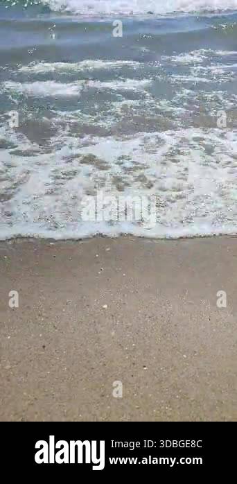 Sea waves with turquoise transparent water rolling onto sand of sandy ...