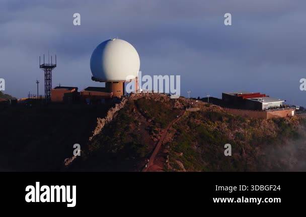 Aerial pan shows Pico do Arieiro, Madeira, with white radome, towers ...
