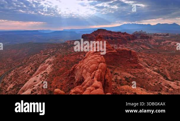 Sunset rays over red rock formations in Arches National Park. Desert ...