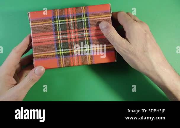 Writing "Thank You" Note Next to Plaid Gift Box; Top view of a hand ...