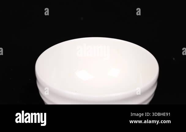Peanuts dropping into a white bowl Stock Video Footage - Alamy