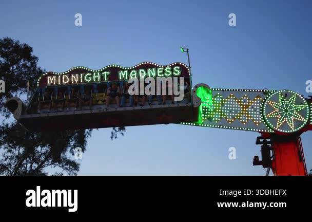 Amusement park ride swings and lights up at dusk Stock Video Footage ...