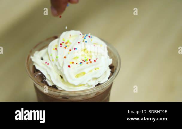 Adding sprinkles to whipped cream-topped drinks Stock Video Footage - Alamy