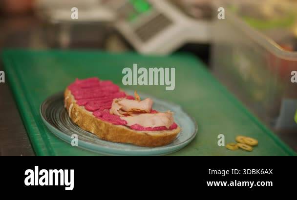 Cooking process. Preparing sandwich. Chef adding sliced meat in pink ...