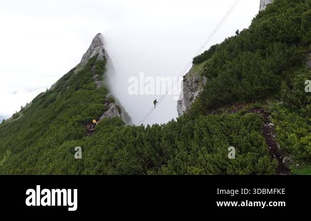 Breathtaking aerial footage of a mountaineer crossing a narrow ...
