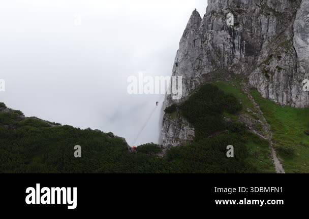 Mountaineers traversing a suspended ladder bridge, a challenging via ...