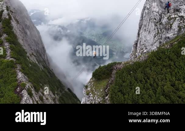 Aerial footage showing a brave mountaineer wearing a helmet and safety ...
