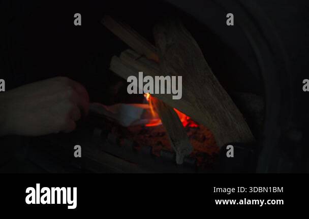 The process of lighting a fire in a fireplace, close-up. A piece of ...