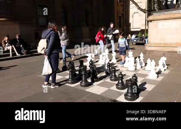 People playing giant chess outside library Stock Video Footage - Alamy
