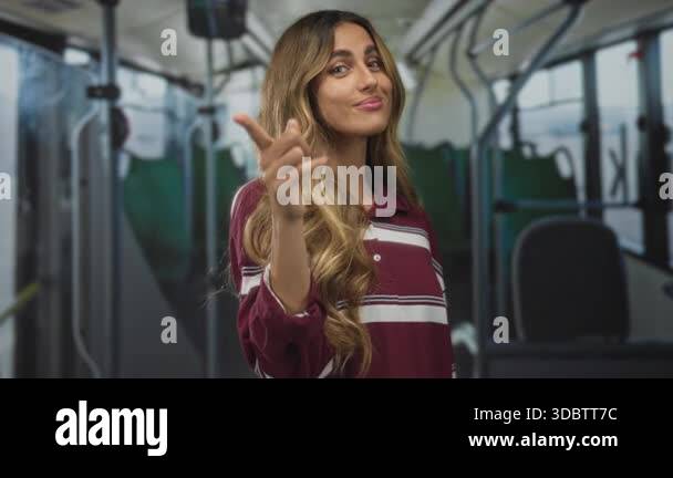 Focused young blonde woman pointing finger inside bus; confidence ...