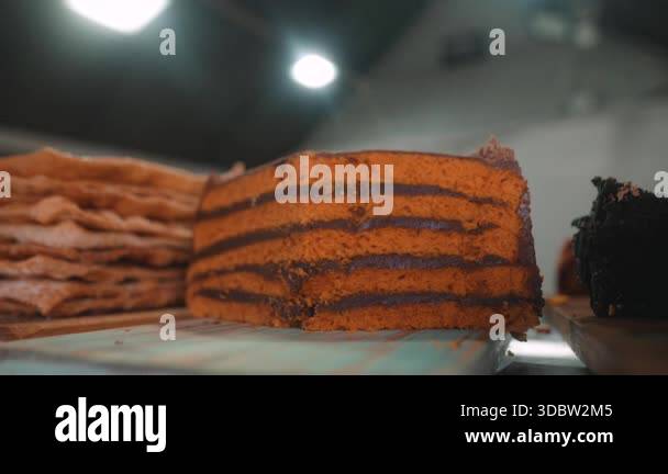 Striped orange chocolate cake slice on display case with dark chocolate ...