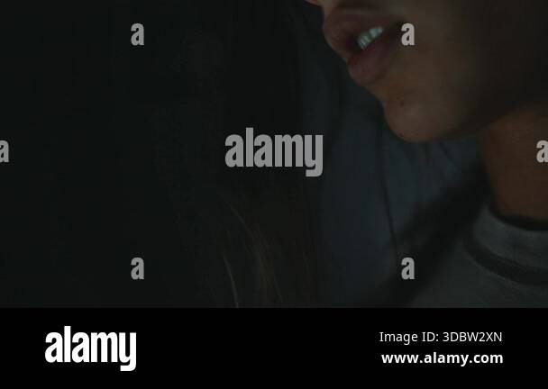 soft lit profile of young woman lower face, closeup lips and chin in ...
