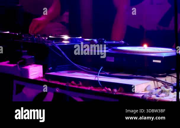 DJ mixing live on stage with professional turntables, audio mixer and ...