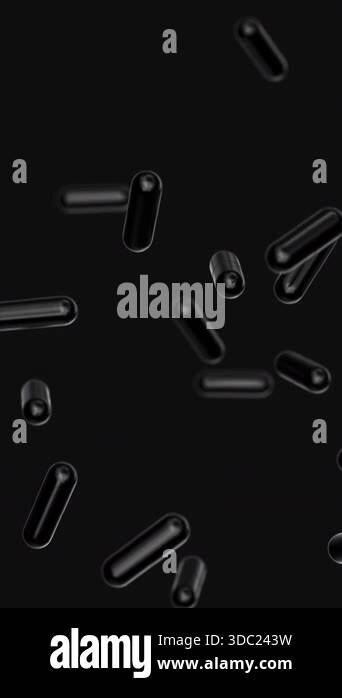 Black capsules slowly fall against black backdrop. Drugs, pills ...