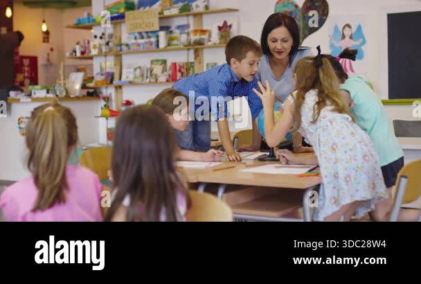 Teacher and elementary students learning geography with globe in ...