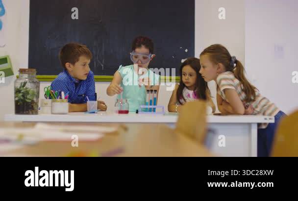 Curious elementary school children doing science experiment in ...
