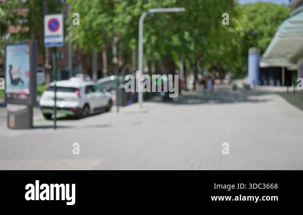 Blurry outdoor street scene with defocused cars, advertisement, people ...