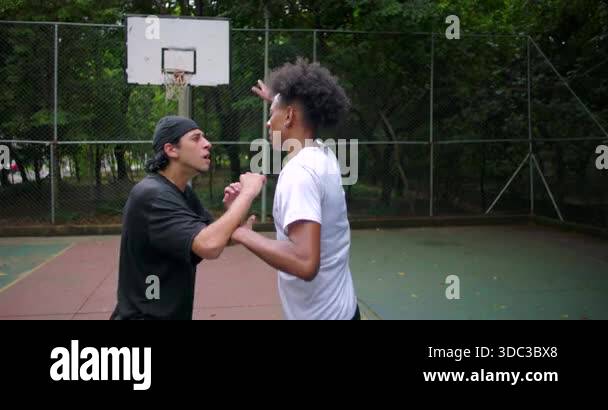 Hispanic and African descent men arguing on outdoor basketball court ...