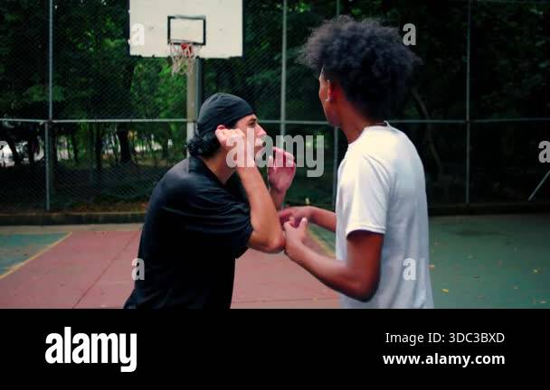 Hispanic and African descent men arguing on outdoor basketball court ...