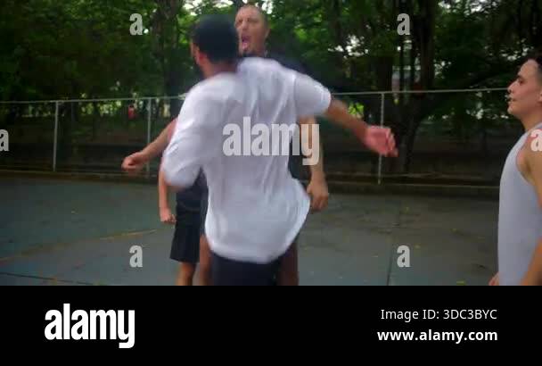 Friends celebrating with energetic chest bump on outdoor basketball ...
