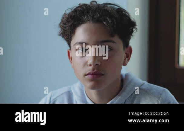 Teen boy faces the camera with a neutral and steady expression ...