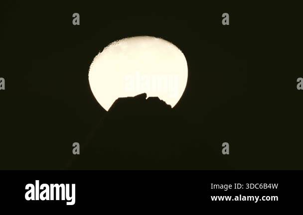 Cairo,Egypt - December 3, 2025: The moon sinking just behind the apex ...