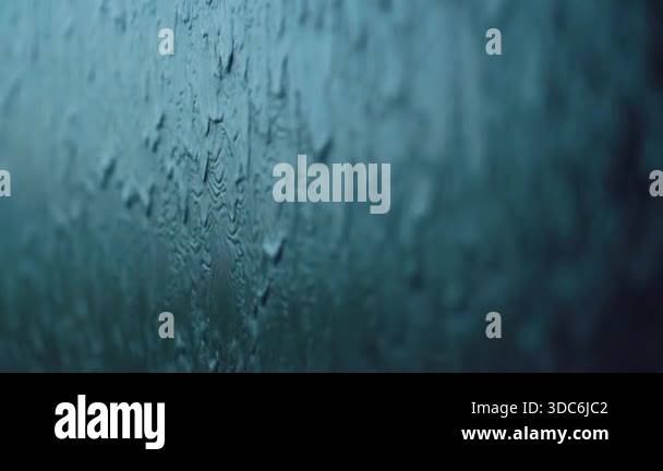 slow motion of water flowing down from modern wall, streams dripping on ...