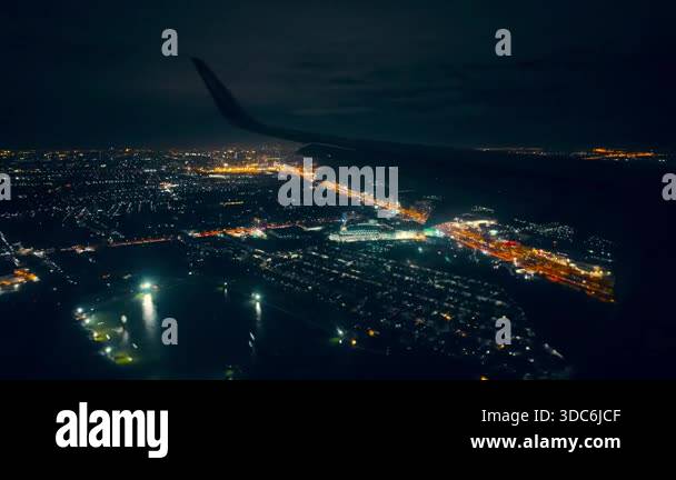 airplane flying over light of big city at night, take off or landing ...
