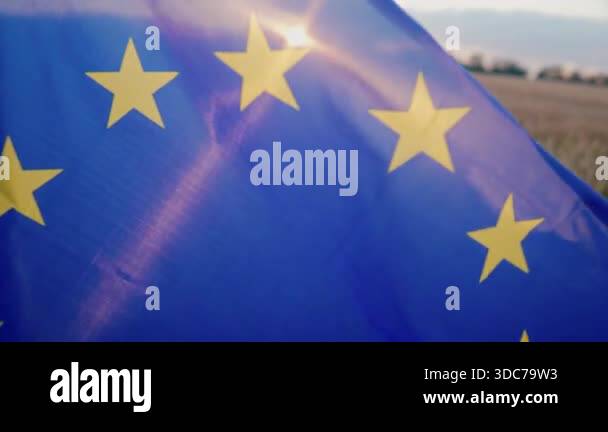 European Union flag waving in warm glow of sunset. Unity, hope, shared ...