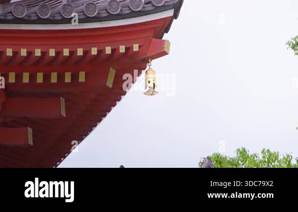Slow motion close-up of the edge of a red pagoda roof at a traditional ...