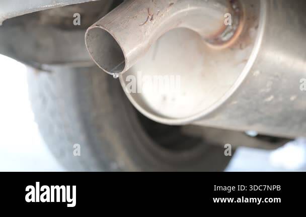 Close-up of a car exhaust pipe as the engine revs, producing strong ...