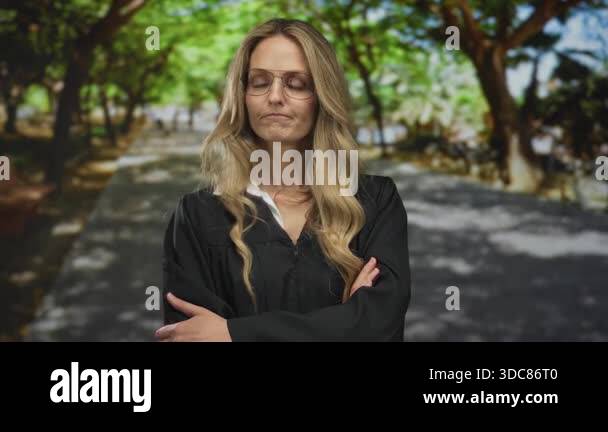 Woman in judge uniform stands confidently in outdoor park setting with ...