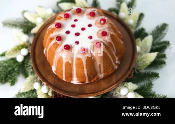 Holiday bundt cake with white icing and red berries, festive evergreen ...