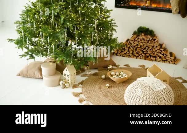 Decorated evergreen tree with lights and icicles near fireplace with ...