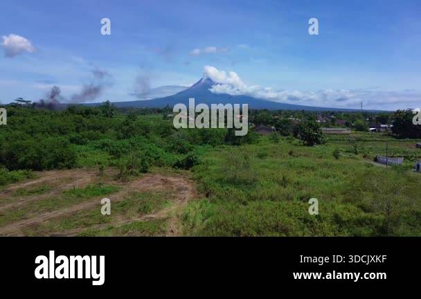 4K aerial view of a volcano with a beautiful rural and rice paddy ...