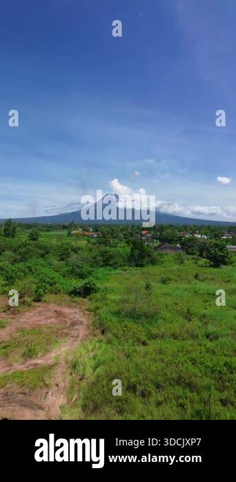 4K aerial view of a volcano with a beautiful rural and rice paddy ...