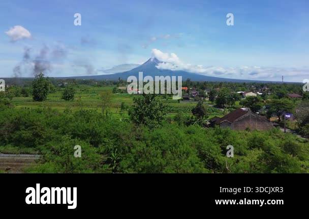 4K aerial view of a volcano with a beautiful rural and rice paddy ...