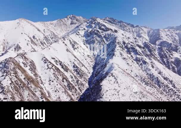 Aerial view captures snow-covered mountains in Kyrgyzstan during winter ...